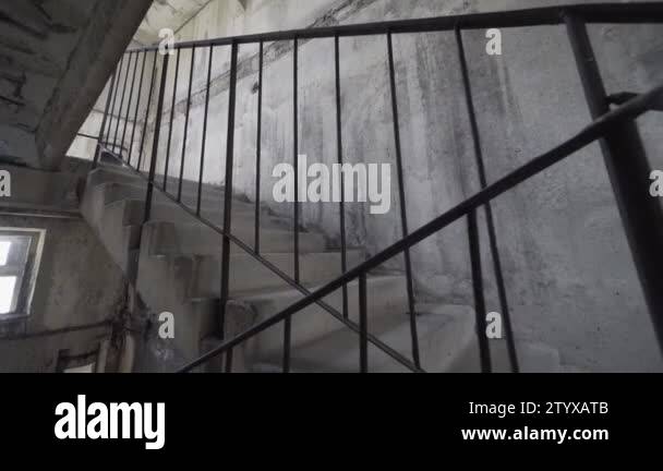 Shaky camera comes towards damaged staircase leading nowhere. Exploring ...