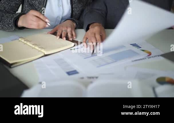 Male and female hands with blocknote, diagrams and pie chart lying on ...