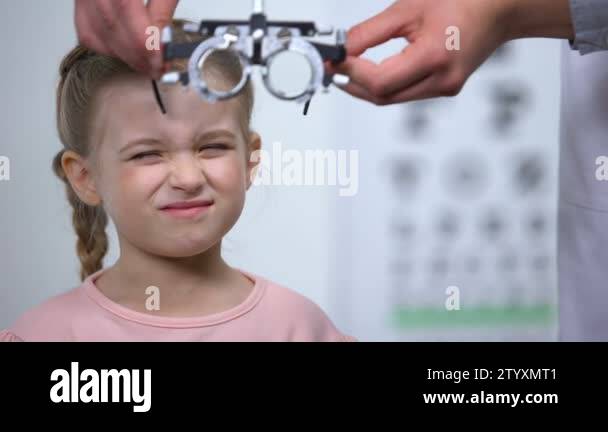 Doctor wearing optical trial frame on child to diagnose myopia, blurred ...