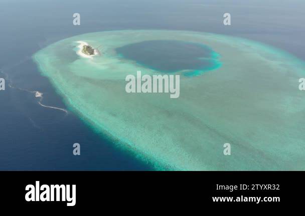 Aerial: Flying over idyllic atoll, travel destination Wakatobi National ...