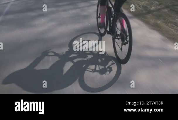 Female muscular feet are pedaling on road bike, close up. Woman riding ...