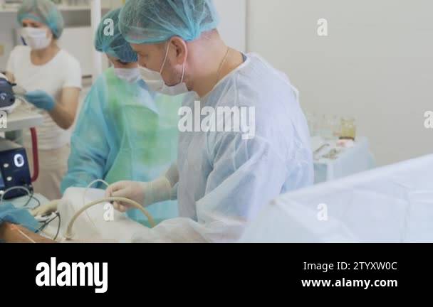 Surgeon makes ultrasound during removal of varicose veins on leg and ...