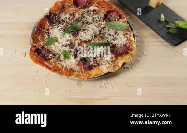 Professional chef places fresh green basil leaves on top of salami ...