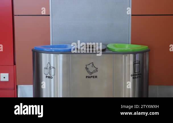 Woman throwing garbage into trash box with paper plastic and glass ...