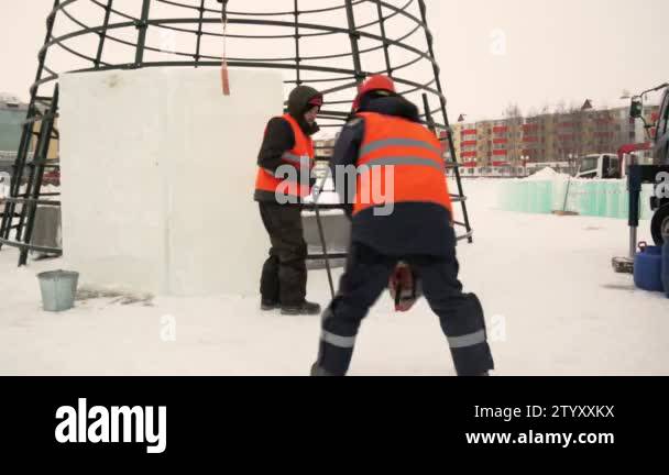 Installers at the construction of the ice town Three workers at the ...