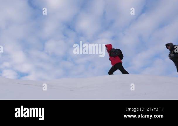 Travelers follow one another along snowy ridge. well-coordinated ...