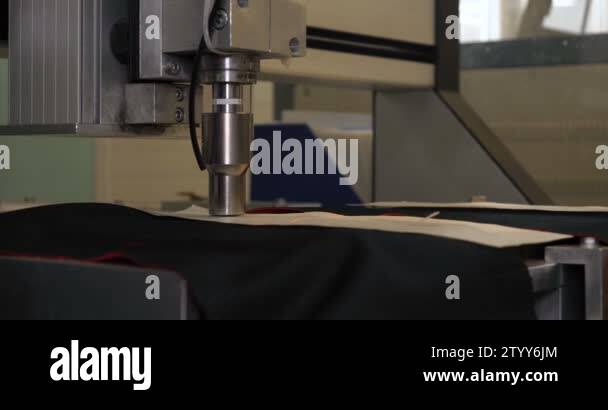 In a slow motion video in a garment factory, women press (cut) various ...