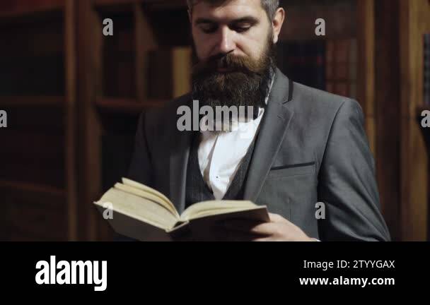 Man with beard reading book on bookshelf background. Intelligent elite ...