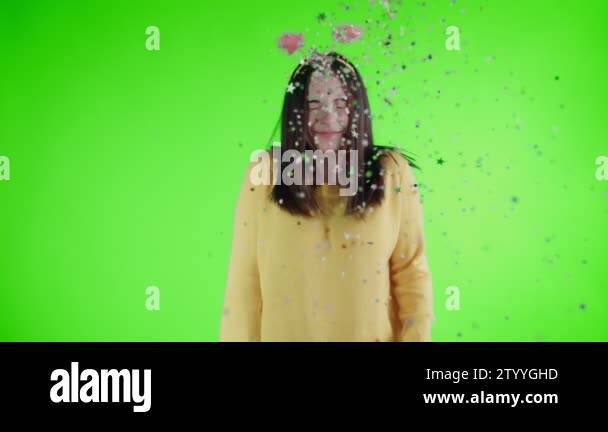 Confetti was thrown at the yong girl on a green screen Stock Video ...