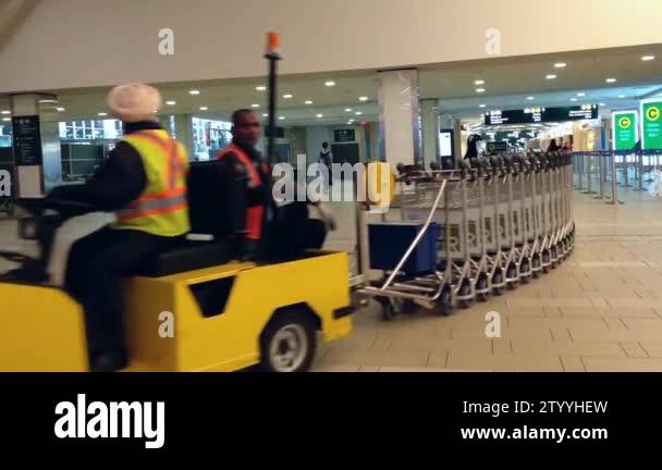 Airport workers moving stacks of luggage carts Stock Video Footage - Alamy