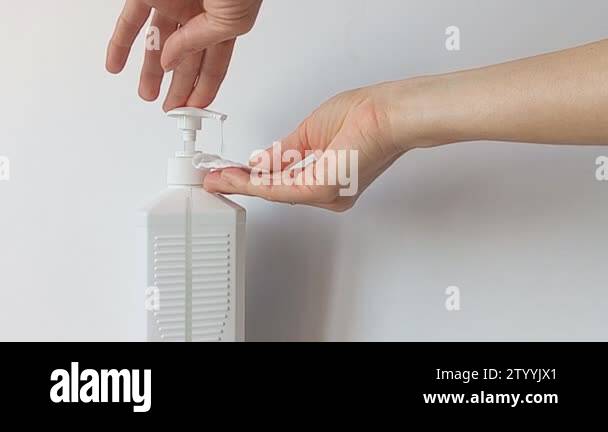 Women's hands disinfect the surface of a computer mouse with a special ...