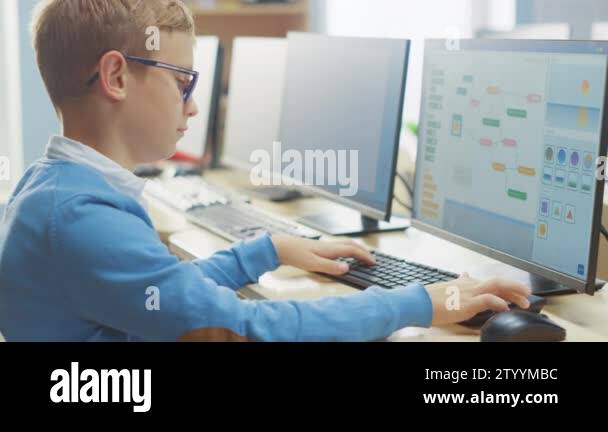 Elementary School Computer Science Classroom: Cute Little Boy wearing Glasses Uses Personal ...