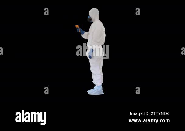 Doctor wearing protective clothes using infrared forehead thermometer ...