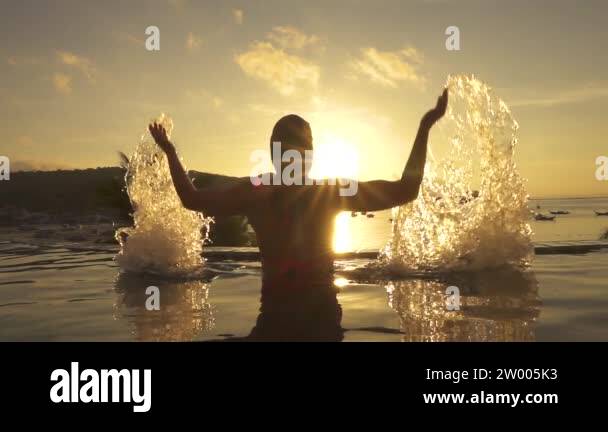 SLOW MOTION, CLOSE UP, LENS FLARE: Playful woman relaxing in infinity ...