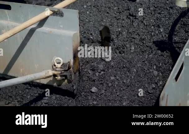 professional equipment with a mixer is blending a mix of rubble, tar ...