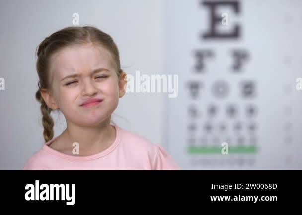Little girl trying to read letters from eye chart, diagnostic of ...
