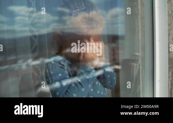 The child is at home in isolation outside the window, crying and wants ...