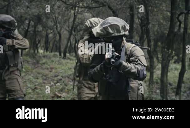 Squad of fully armed commando soldiers during combat in a forest ...