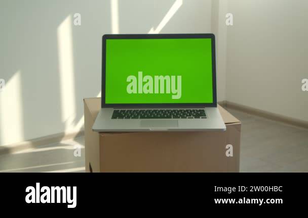 Closeup shoot of laptop with green screen laying on the box in the ...