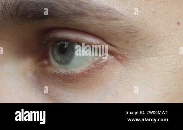 blinking male eye close up. pensive sad look ahead and into the frame ...