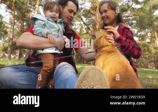 Dad breeder with kids and dog for a walk. A happy family. Papins day ...