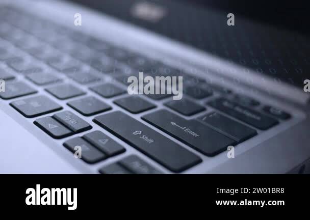 Finger dramatically presses the enter button on laptop with binary code ...