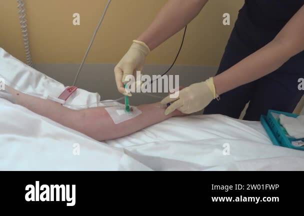 The nurse's hands in sterile gloves are injected into the venous ...