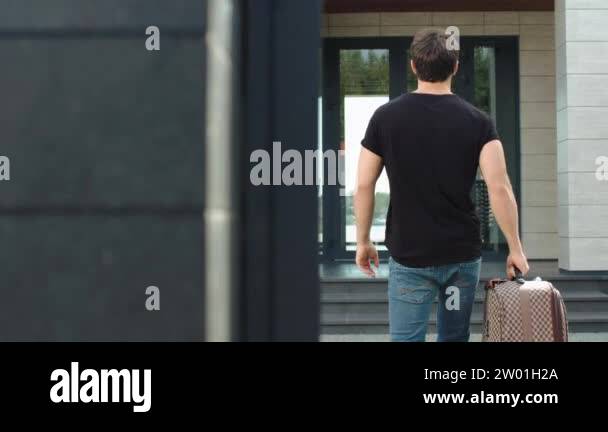 Tourist man caming back home from holiday. Handsome man returning from ...