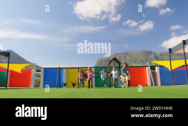 Front view of mixed-race schoolkids playing in the school playground ...