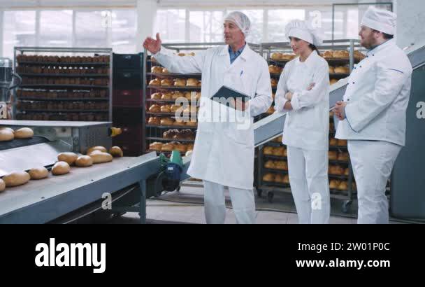 Old man engineer have a chat with two bakers in a bakery industry he ...