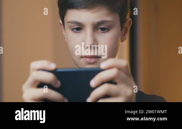 Young boy playing on his smartphone. Kid playing mobile game on smart ...