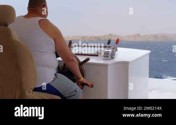 Fat Captain Controls the Tourist Yacht in Sea Storm. Steering Wheel of ...