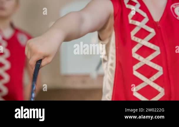 A girl is turning the majorette stick in one hand. They're practising ...