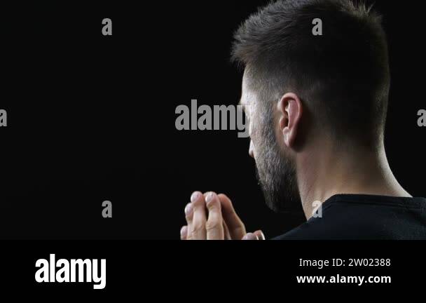 Poor man praying to Jesus Christ against black background, Christianity ...