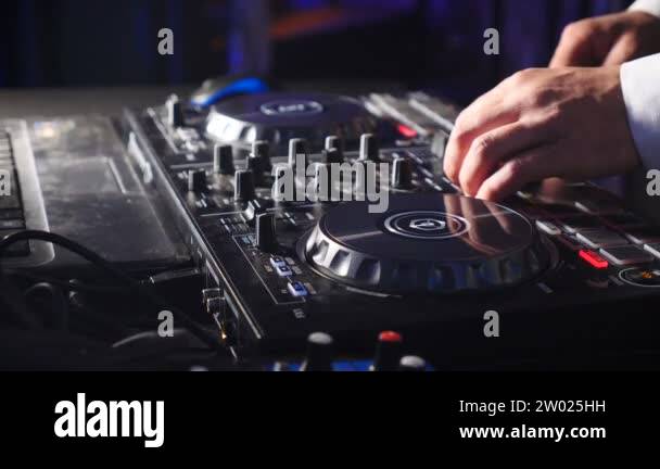 DJ behind console, on stage, mixing tracks in atmospheric dance party ...