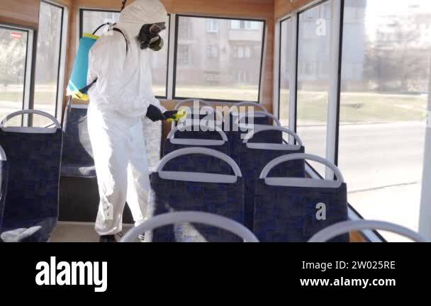 Hazmat team worker disinfects bus interior with antibacterial sanitizer ...