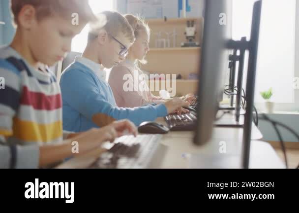 Elementary School Classroom: Portrait of a Smart Boy with Glasses Uses ...