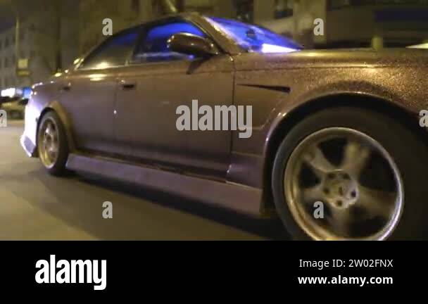 Bottom view of cool car driving on night city. Action. Shiny dark gold ...
