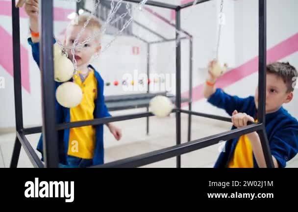 Boys doing experiment with Newton's cradle physics concept for ...
