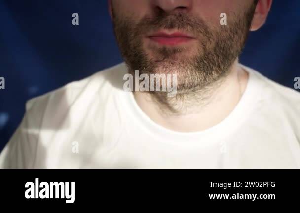 Close-up, a man with stubble eating a chicken leg. Holds nuggets with ...