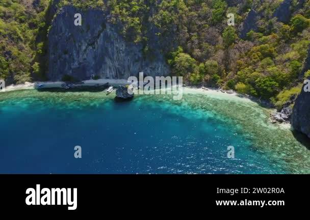 aerial view of filipino boats floating in blue lagoon on top of coral ...