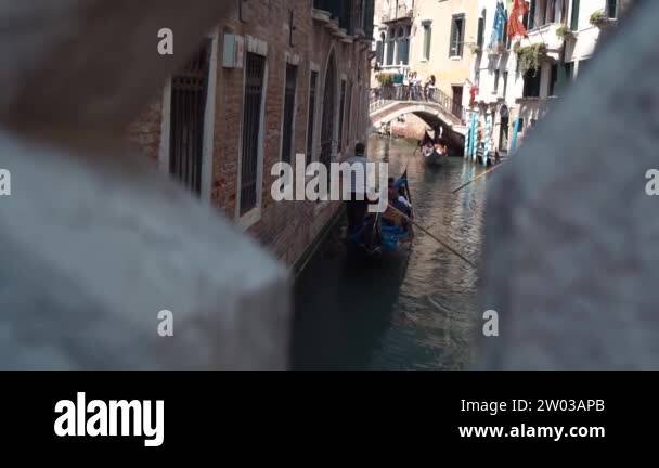 VENICE, ITALY, 2019: Gondolas with tourists swim along a narrow canal ...