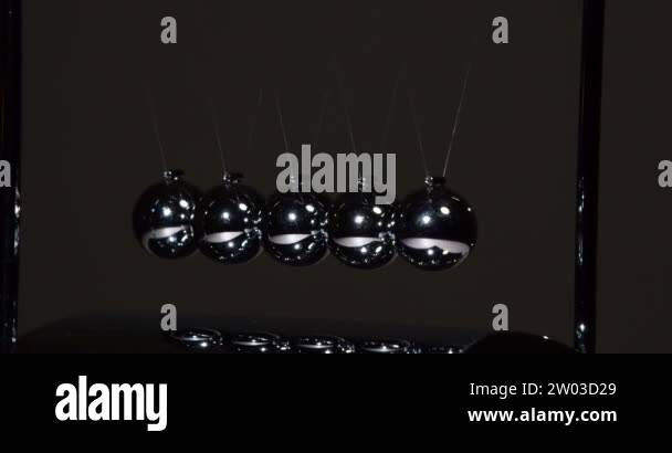 Looped motion Newton Pendulum. Loop. Steel shiny balls suspended on a ...