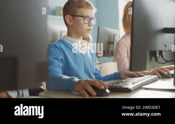 Elementary School Classroom: Portrait of a Smart Boy with Glasses Uses ...