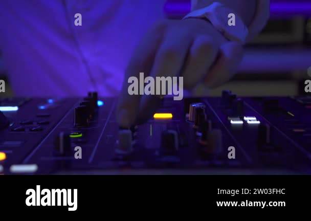 Male hand disk jockey on mixing console for mixing techo music on disco ...