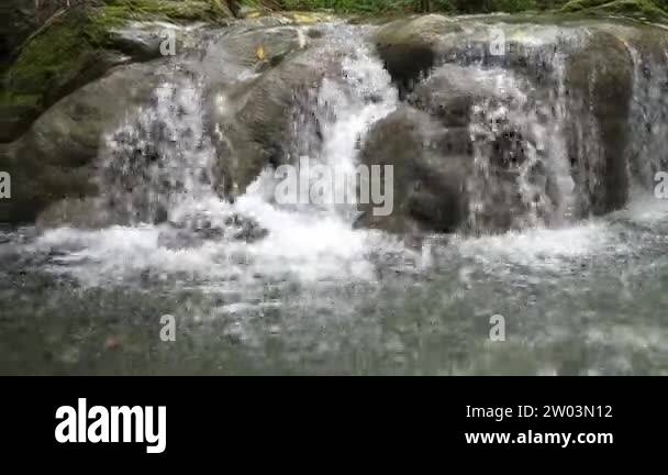 A closeup slow motion of whitewater rapids cascading over rocks in the ...