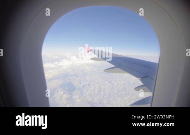 Airplane flight. Wing of an airplane flying above the clouds. View from ...