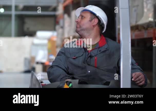 The face of a logistic warehouse worker. A man rides on a specialized ...