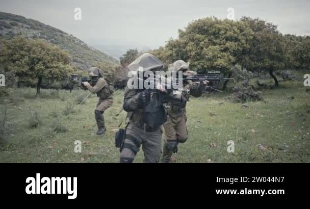 Squad of fully armed commando soldiers during combat in a forest ...