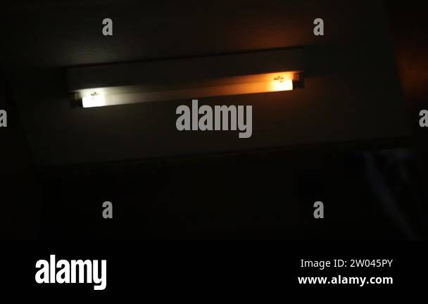 Broken florescent bulb flickering and flashing in the darkness of a ...